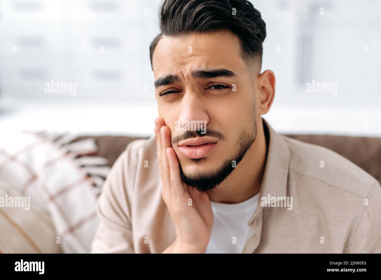 Frustrated unhappy indian or arabian man in casual clothes, pressing ...
