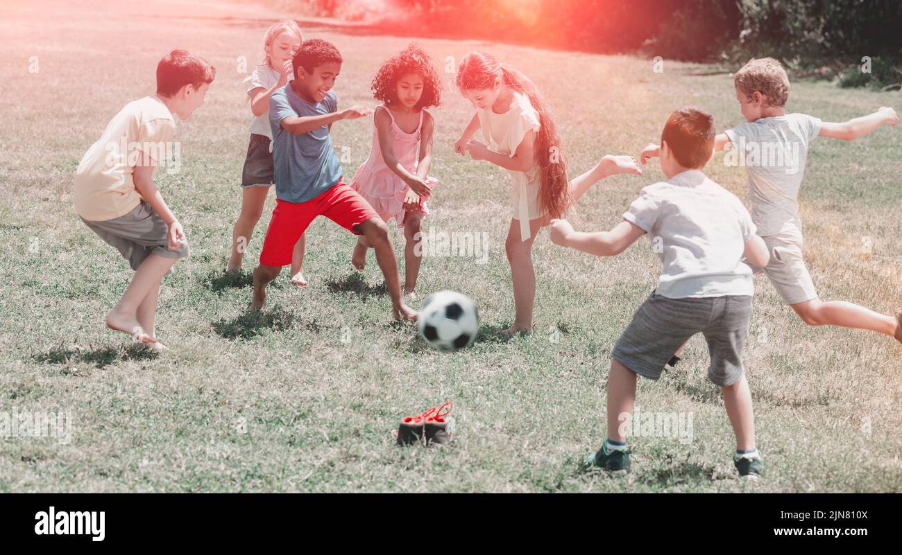 Group of happy schoolchildren playing football together Stock Photo - Alamy