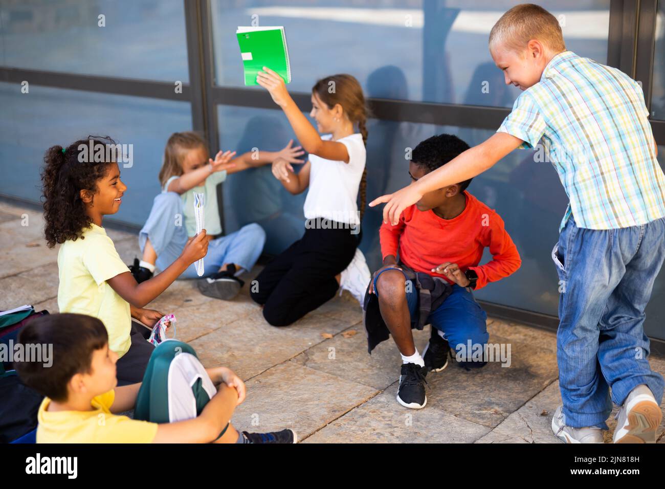 Cheerful preteens resting outdoors in schoolyard during break Stock ...