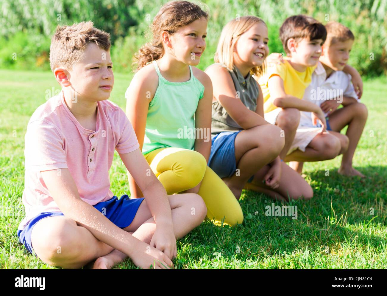Kids sitting on grass Stock Photo - Alamy