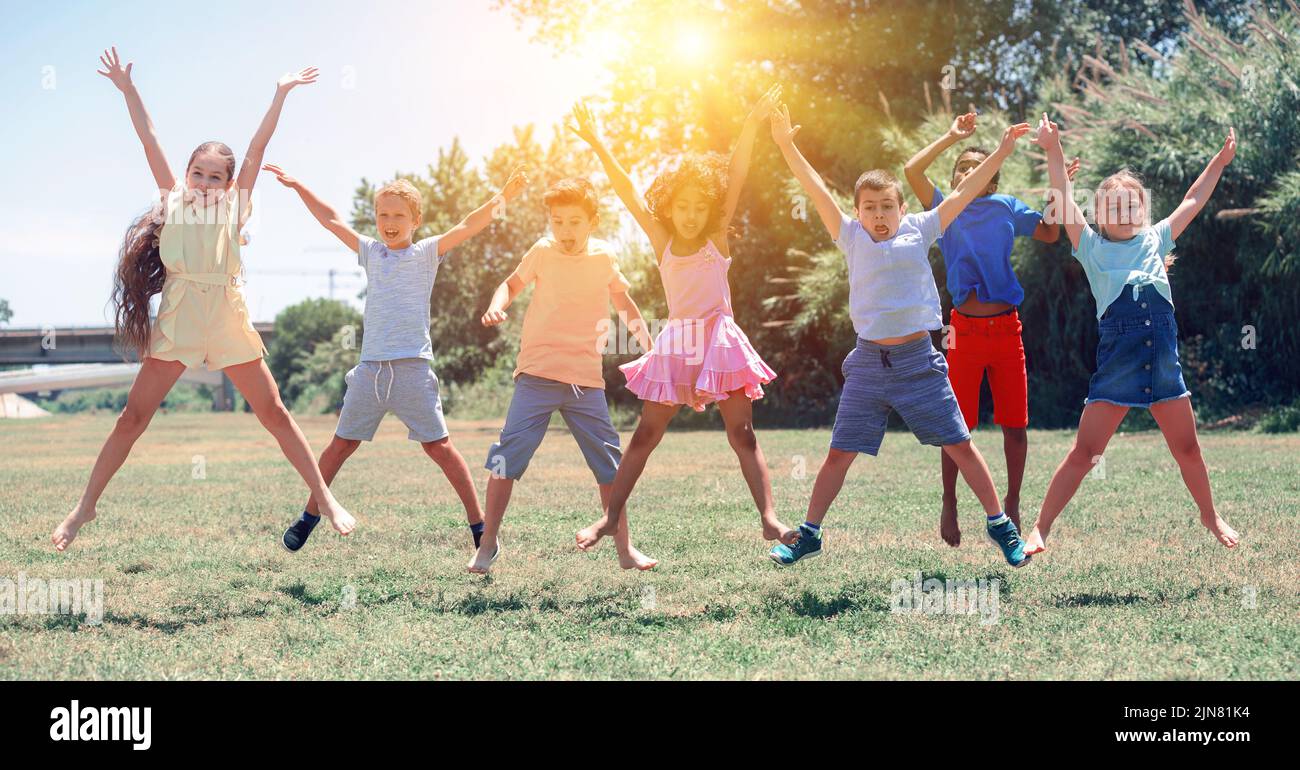 Friendly happy kids jumping together in park Stock Photo - Alamy