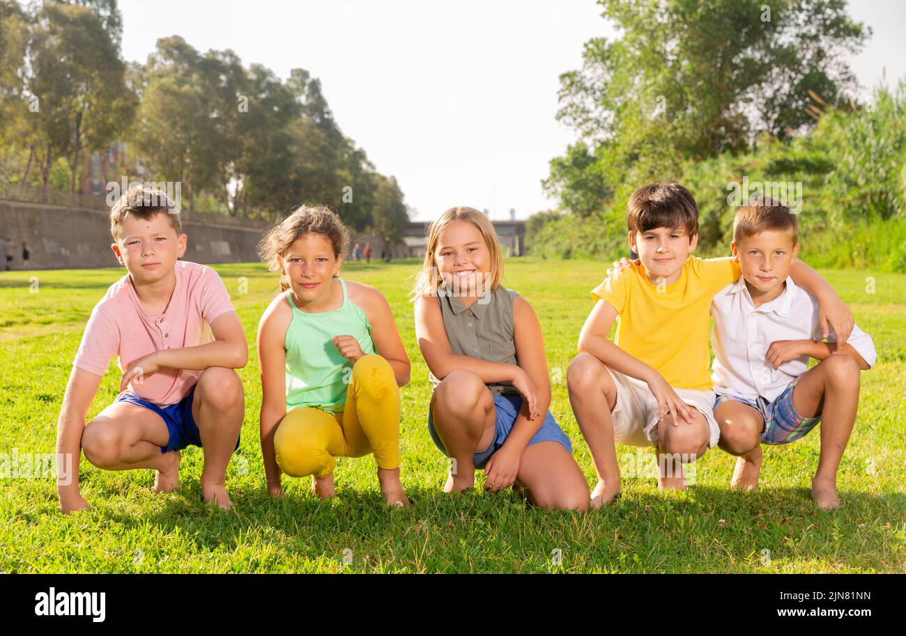 Five kids sitting on grass Stock Photo - Alamy