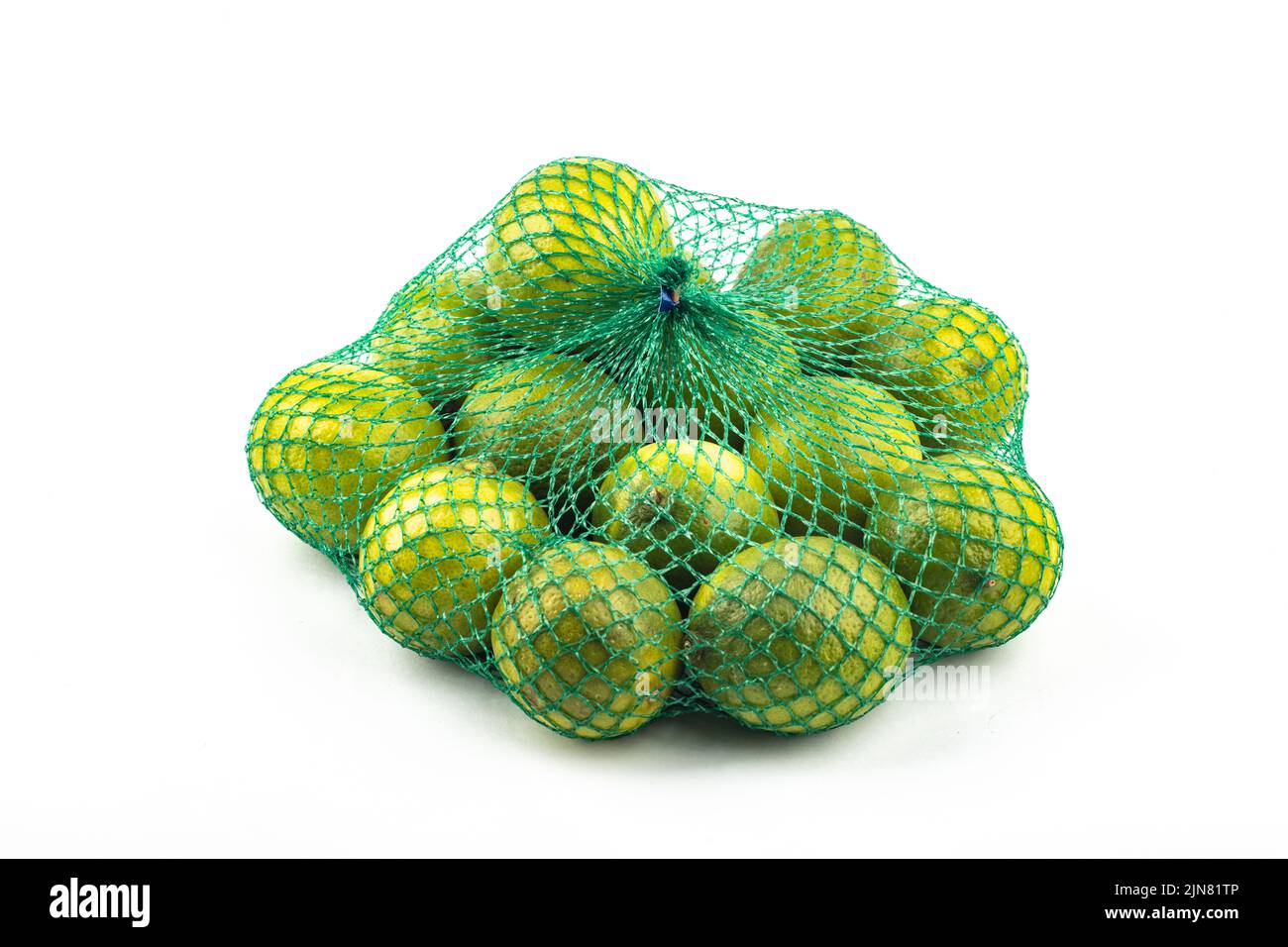Fresh limes in the net green lime citrus fruit stand isolated on white ...