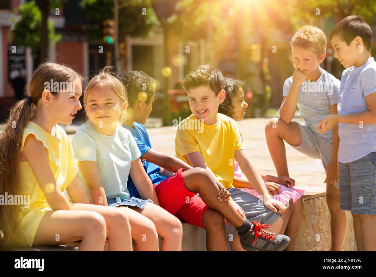 Positive children chatting together sitting at urban street Stock Photo ...