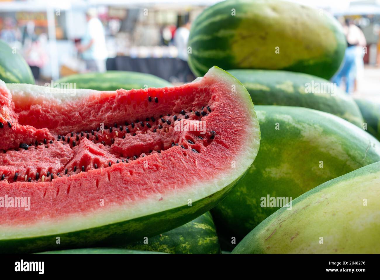 Fresh elongated watermelon with a transverse cut showing a pink chunky ...