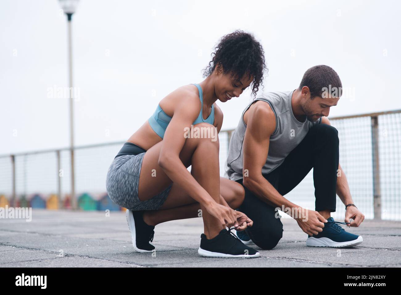 Getting ready to get set. two sporty young people tying their laces while exercising outdoors ...