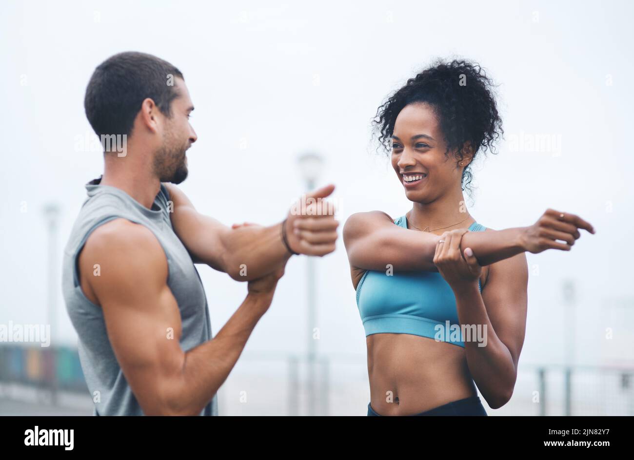 Motivating each other to be better. two sporty young people stretching ...