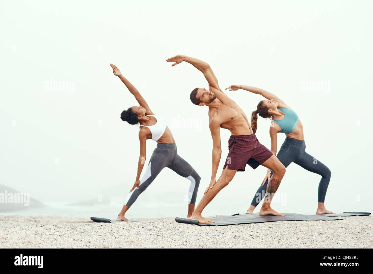 Stretching towards a sense of peace together. a group of young people ...