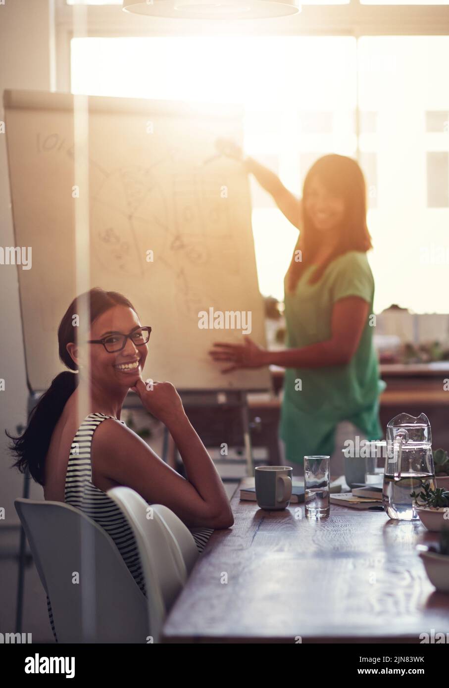 Female business leader presenting on a whiteboard explaining ideas and ...