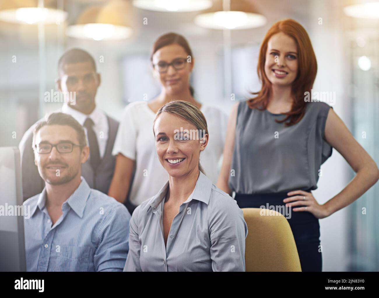 Portrait of a group of a diverse corporate group standing in an office ...