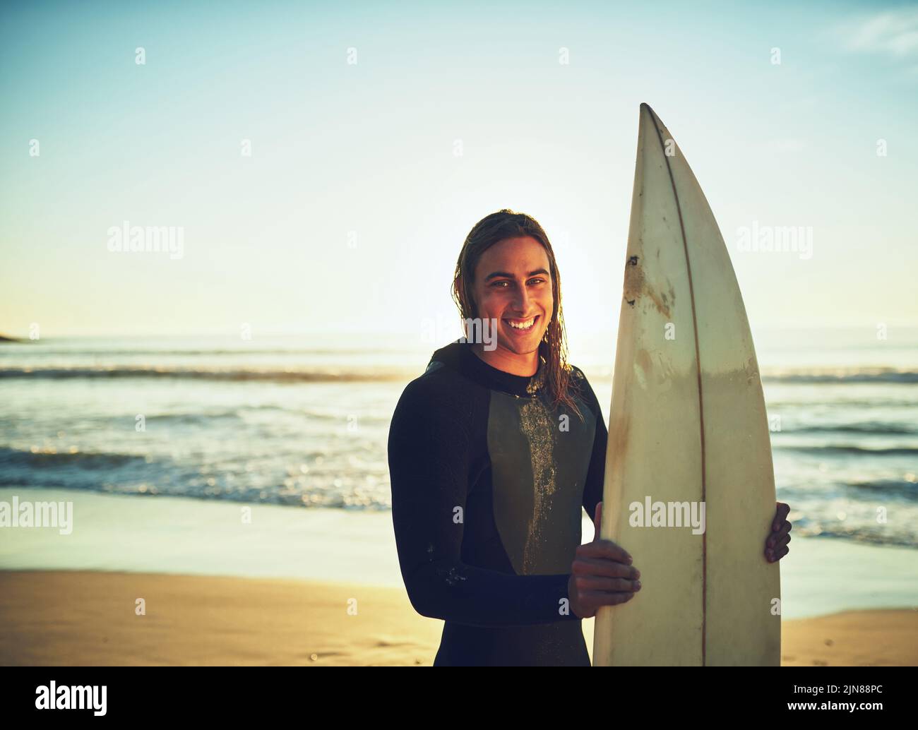 Surfing is an instant mood booster for me. Portrait of a young man ...