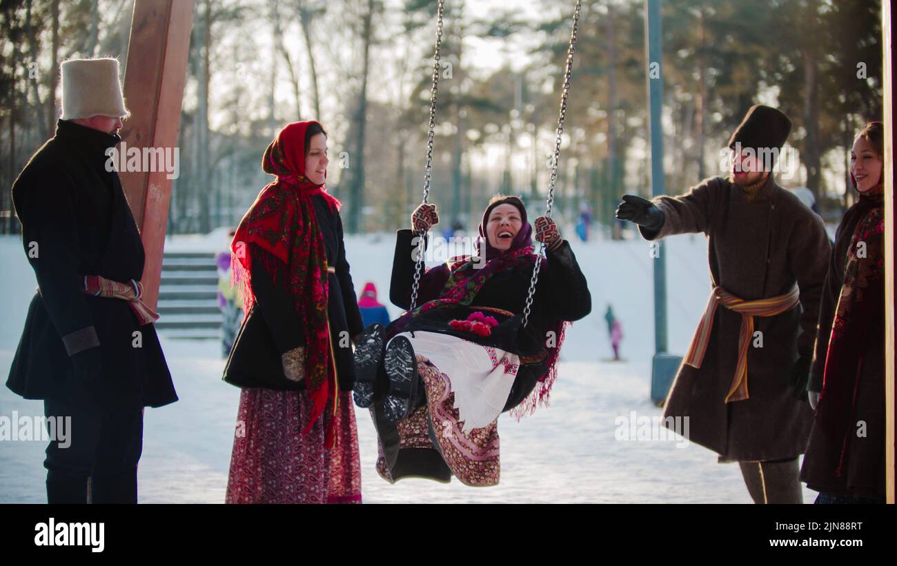 Russian folklore - young woman swinging and everyone is laughing on a ...