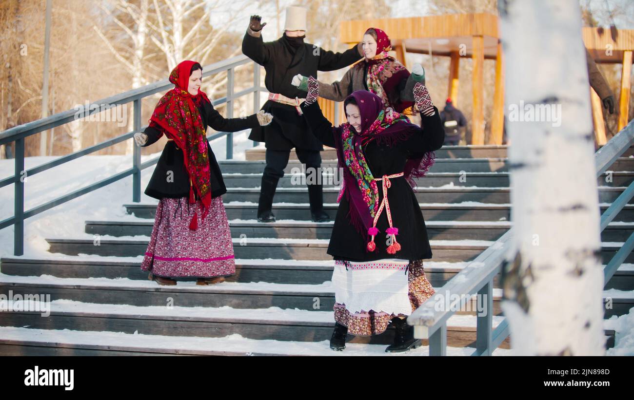 Russian folk - men and women in felt boots are dancing on the stairs in ...