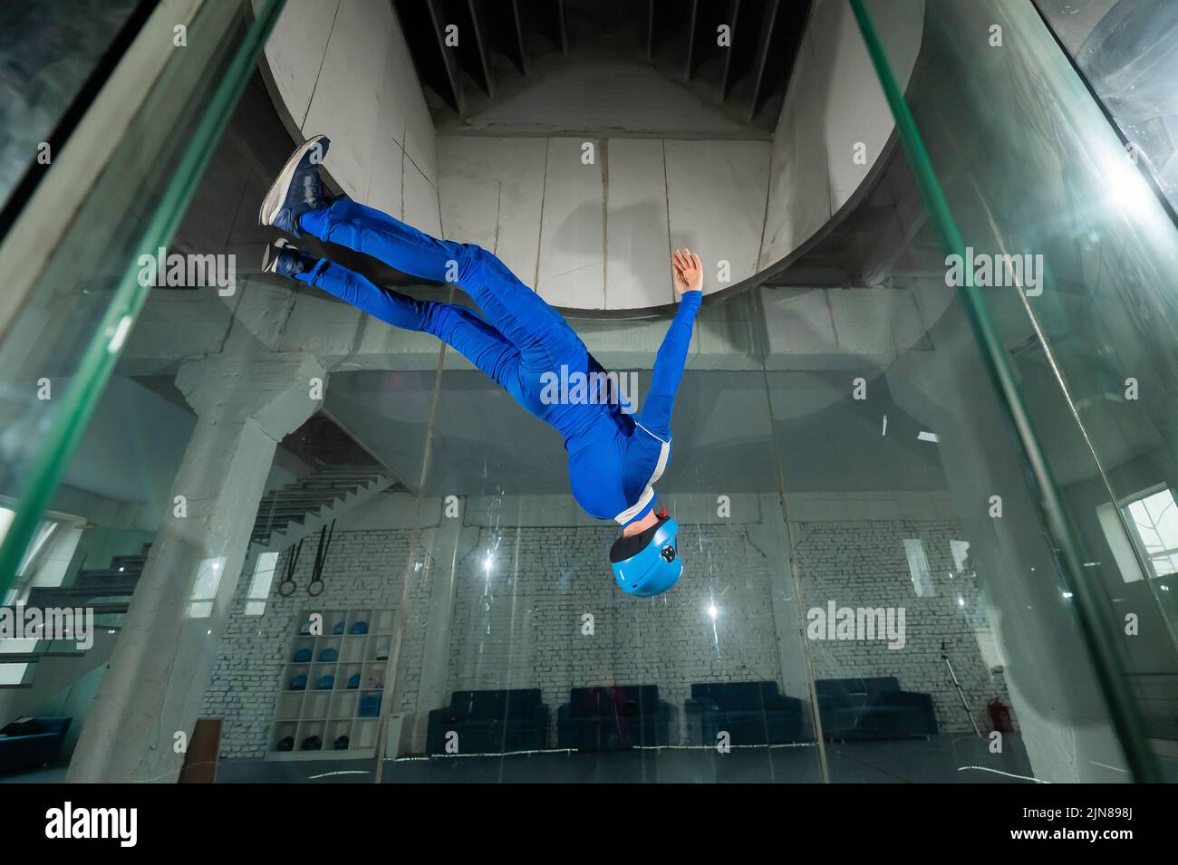A man in overalls and a protective helmet enjoys flying in a wind ...