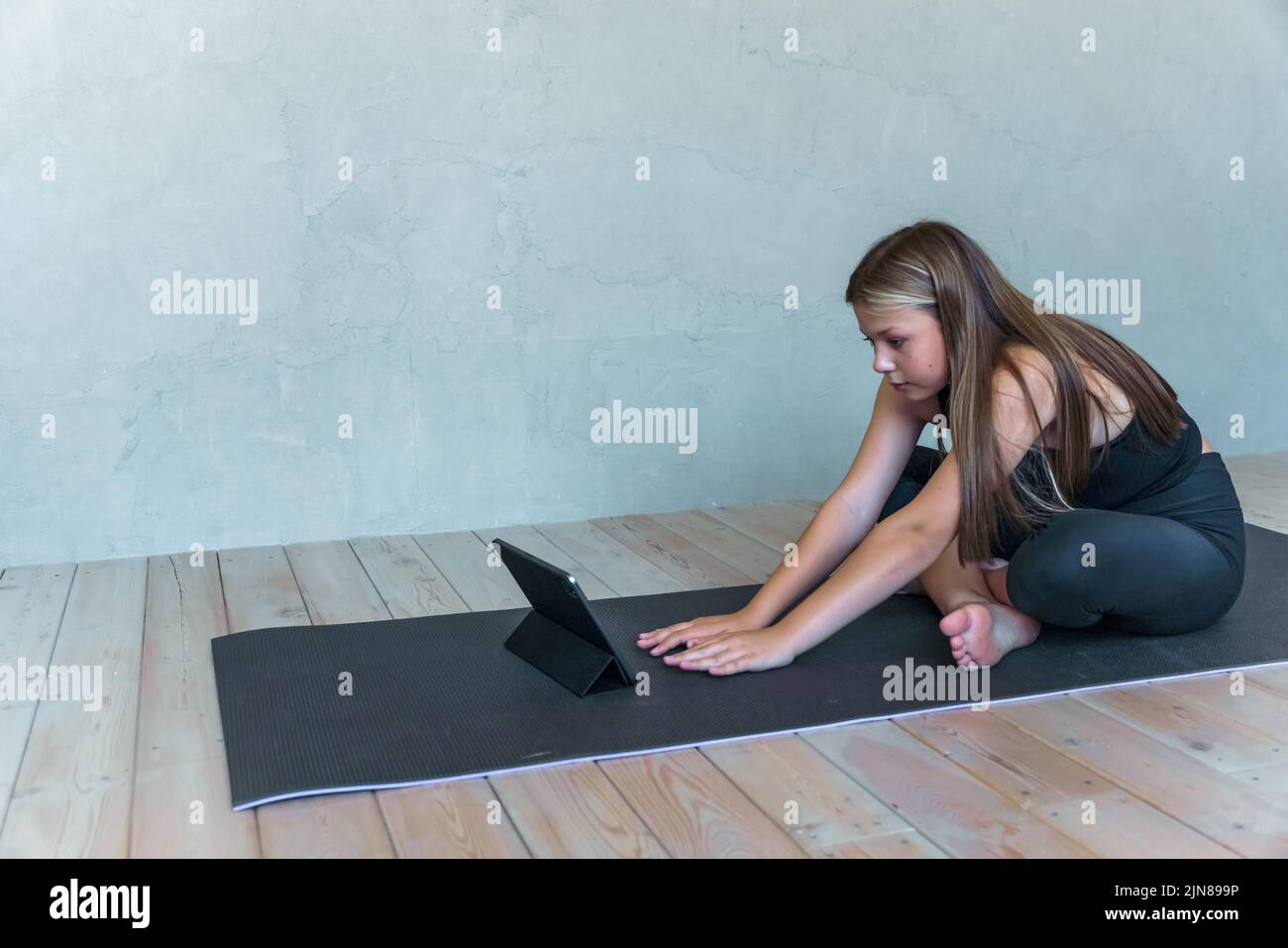 Self isolation workout. Lovely girl in sportswear practicing yoga or ...