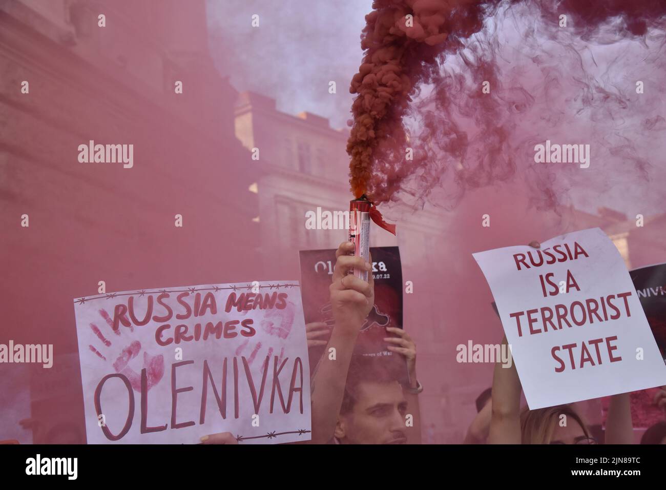 A protester holding a burning red flare during a demonstration ...