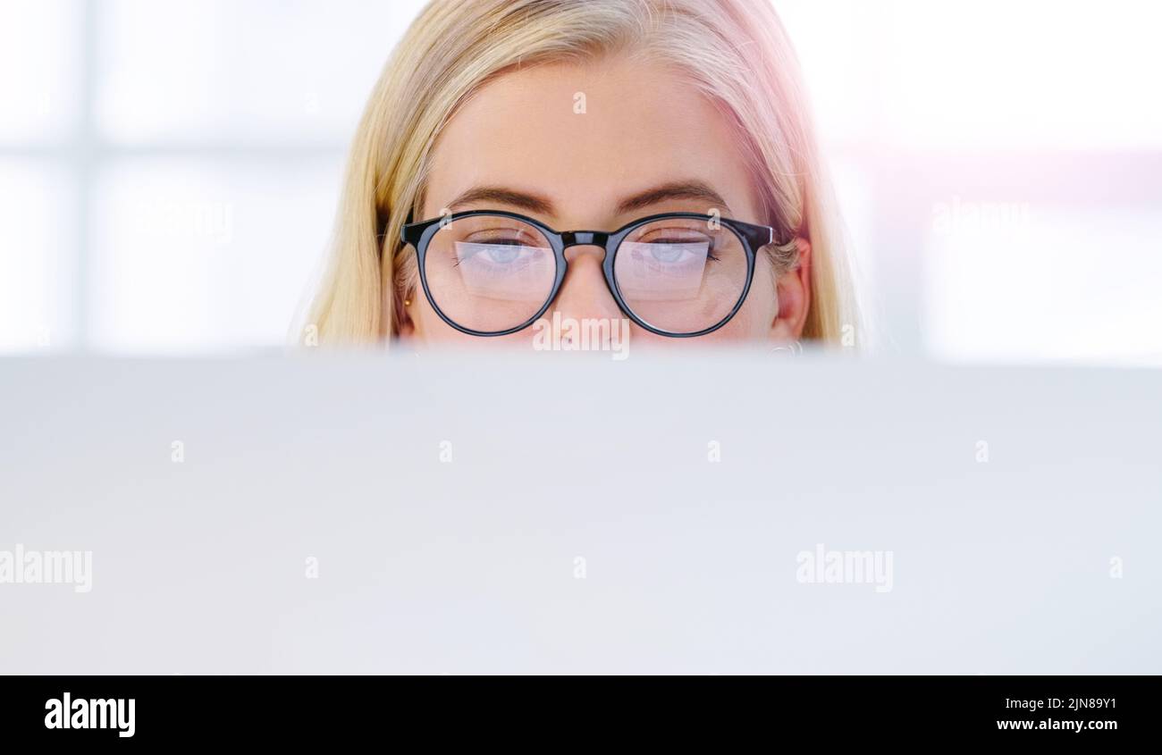 Glued to the screen. a focused young businesswoman working on her ...