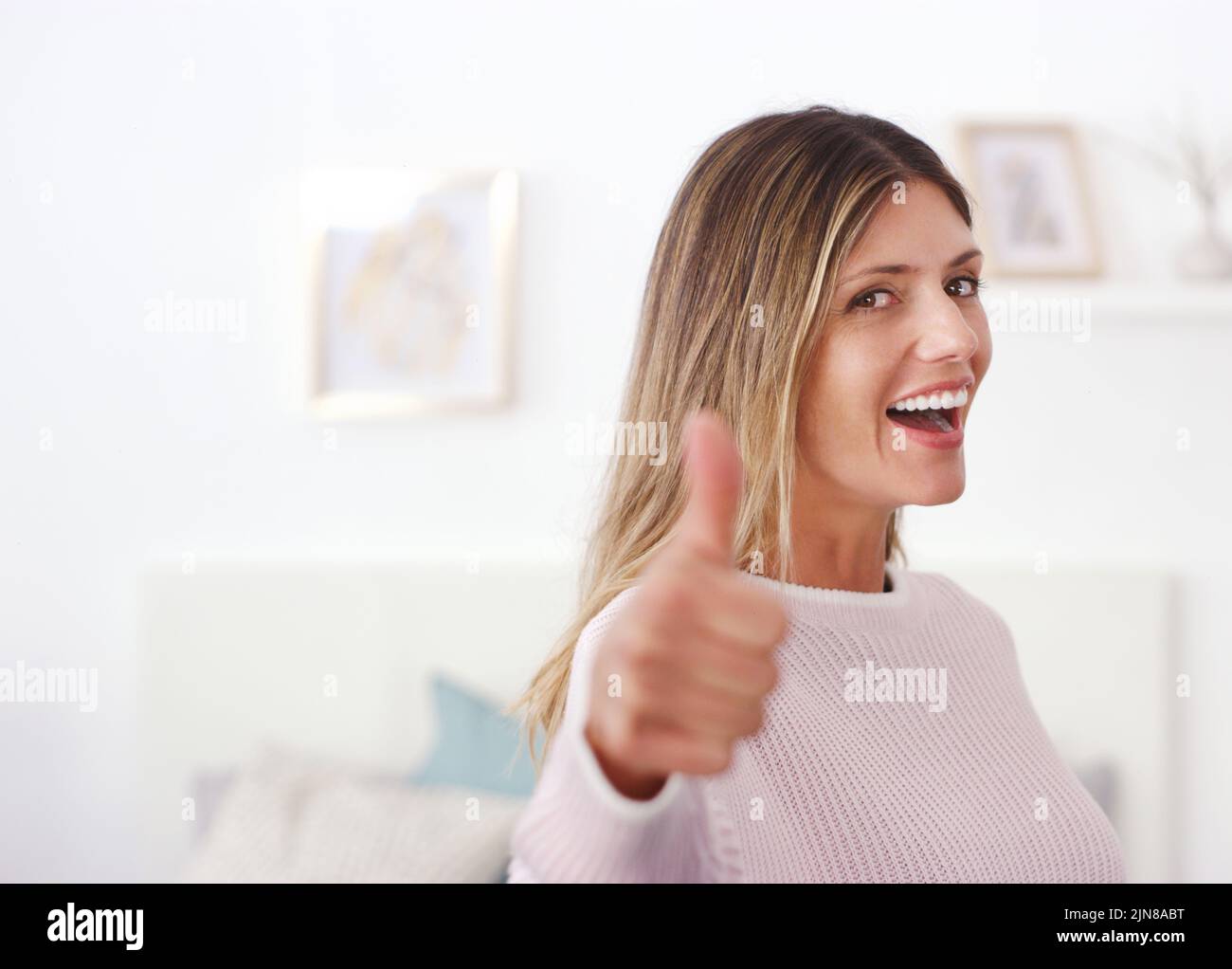 Youre awesome. an attractive woman showing thumbs up Stock Photo - Alamy