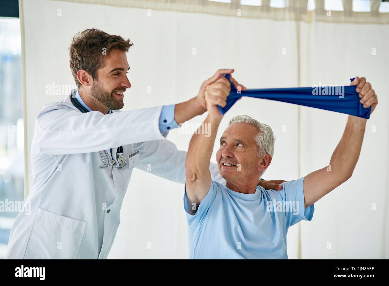 Were doing just fine. a friendly young doctor helping a senior man ...