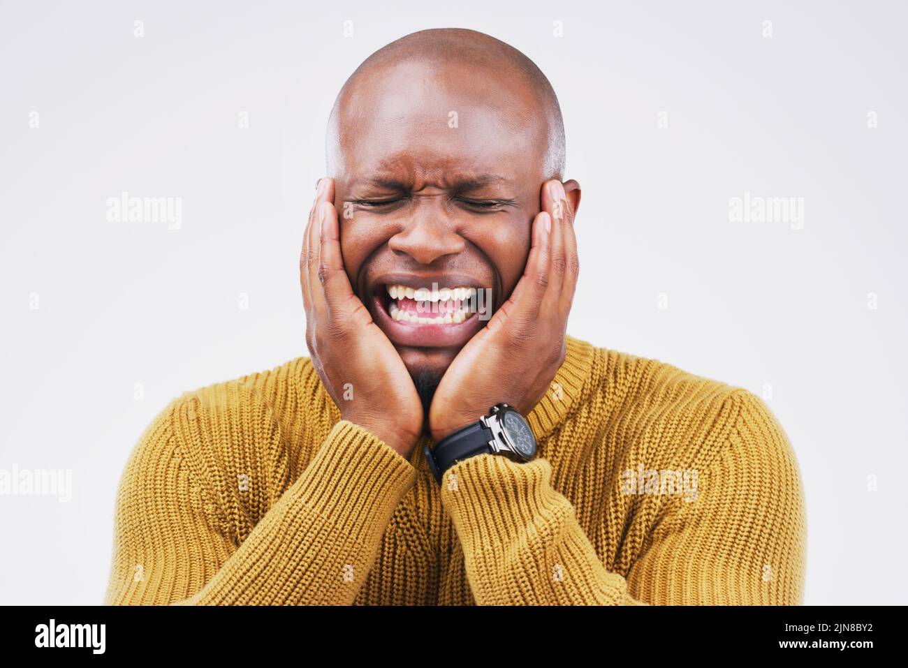 Im not crying. Studio shot of a young man crying while standing against ...