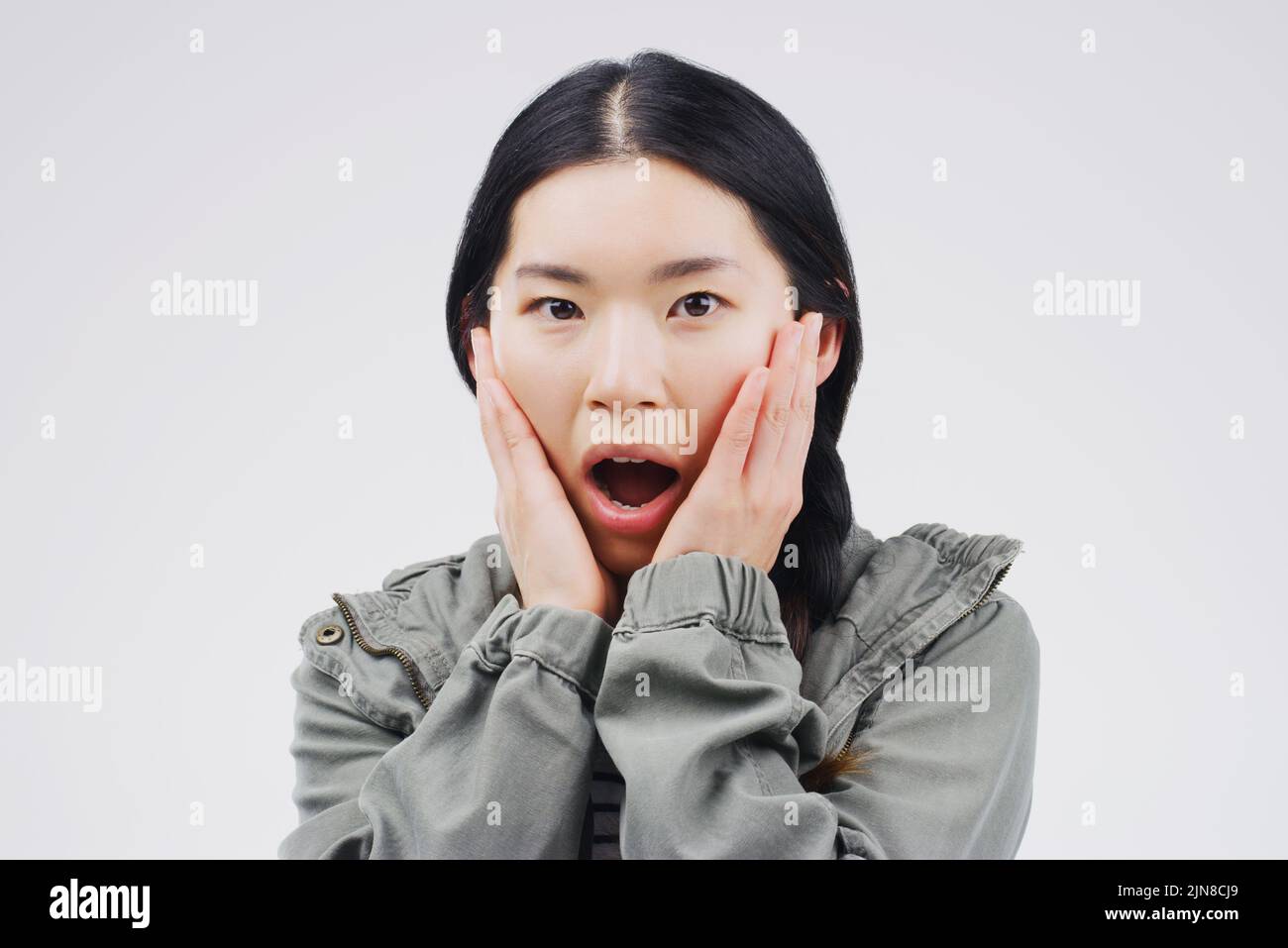 Have you heard. Studio shot of a young woman looking shocked against a grey background Stock ...