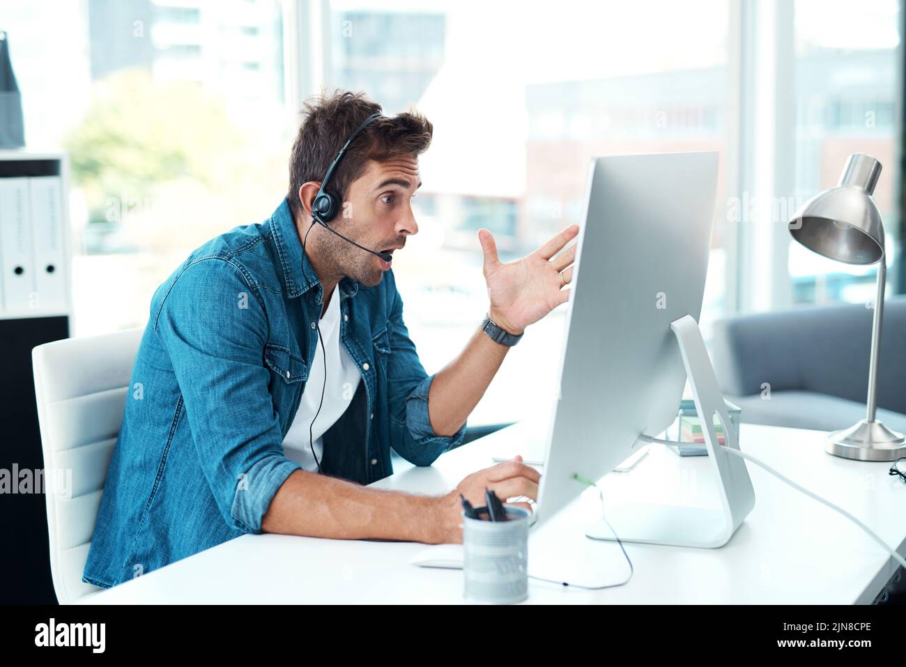 This is unbelievable. a young male call centre agent looking shocked in ...