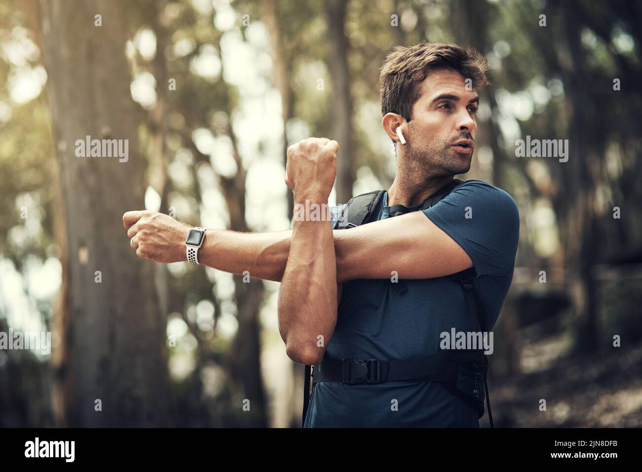 Getting ready for a hike. a handsome young man stretching before ...