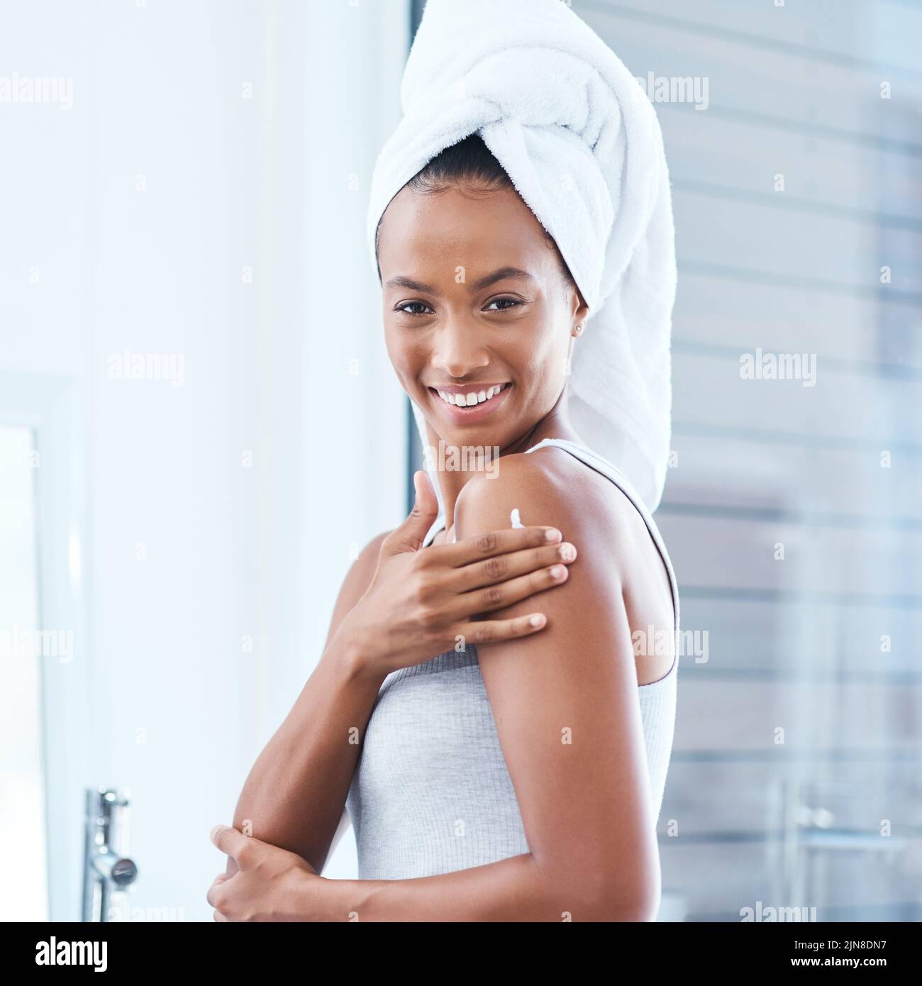 lock in all that moisture. a young woman applying moisturizer to her ...