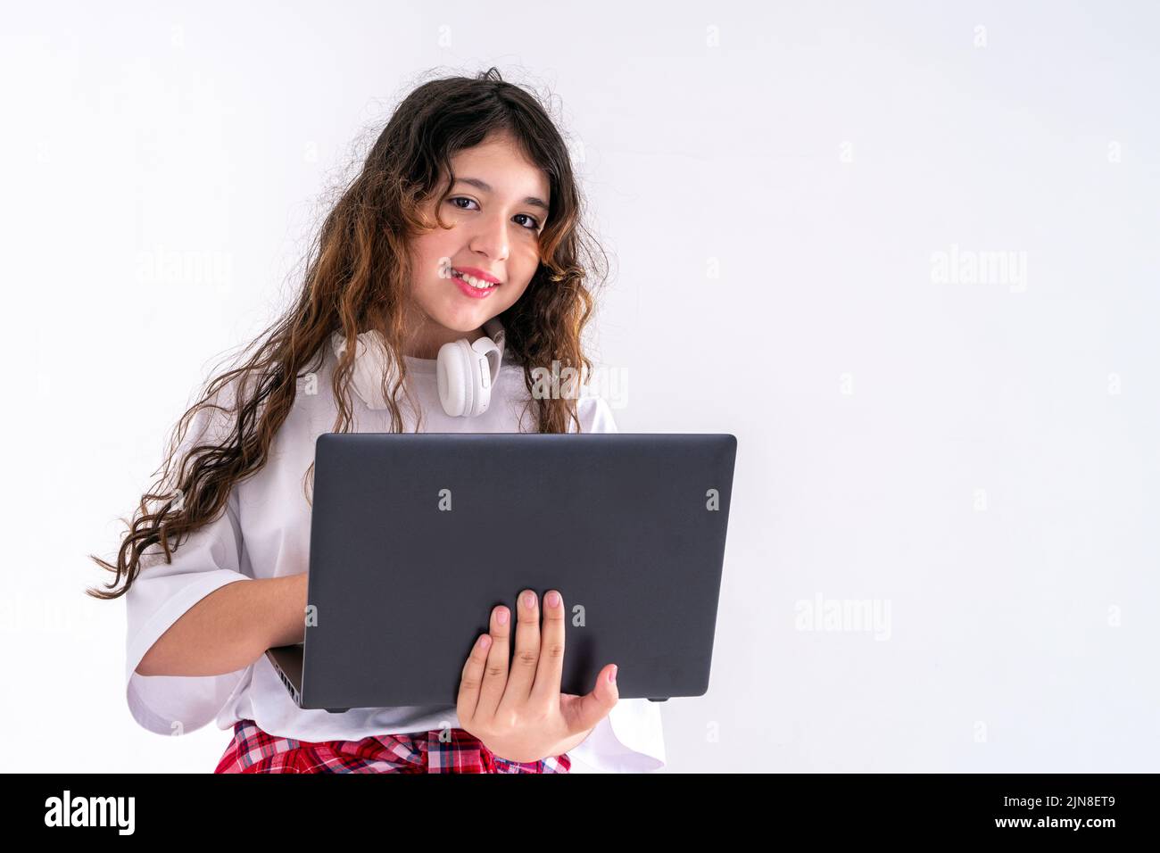 Caucasian middle schoolgirl with laptop pc and headphones smiling in a ...