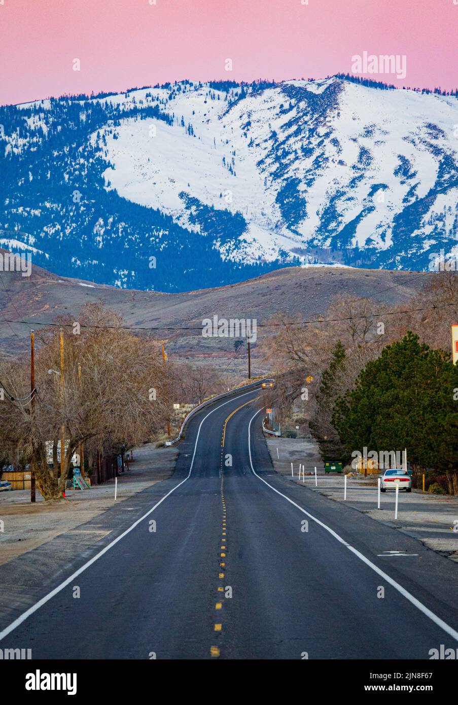 The vertical view of the countryside road and mountain under the pink ...