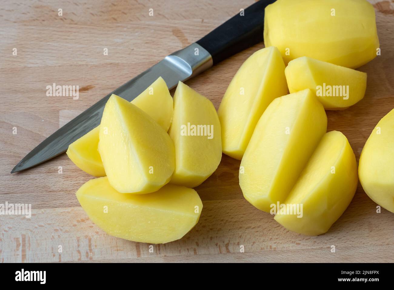 Raw peeled and sliced potatoes on cutting board Stock Photo - Alamy