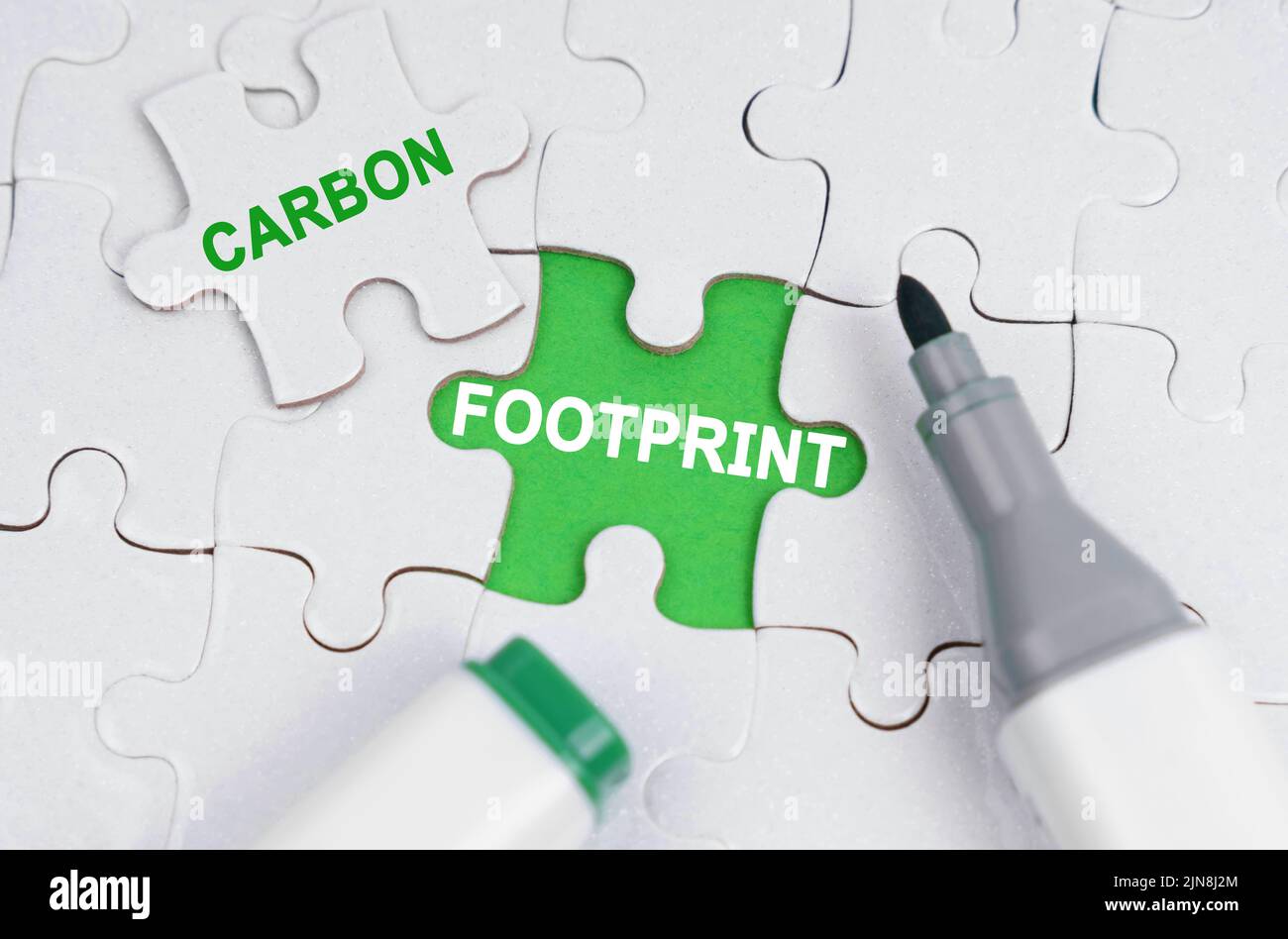 Ecology concept. White puzzles lie on a green background, in place of ...