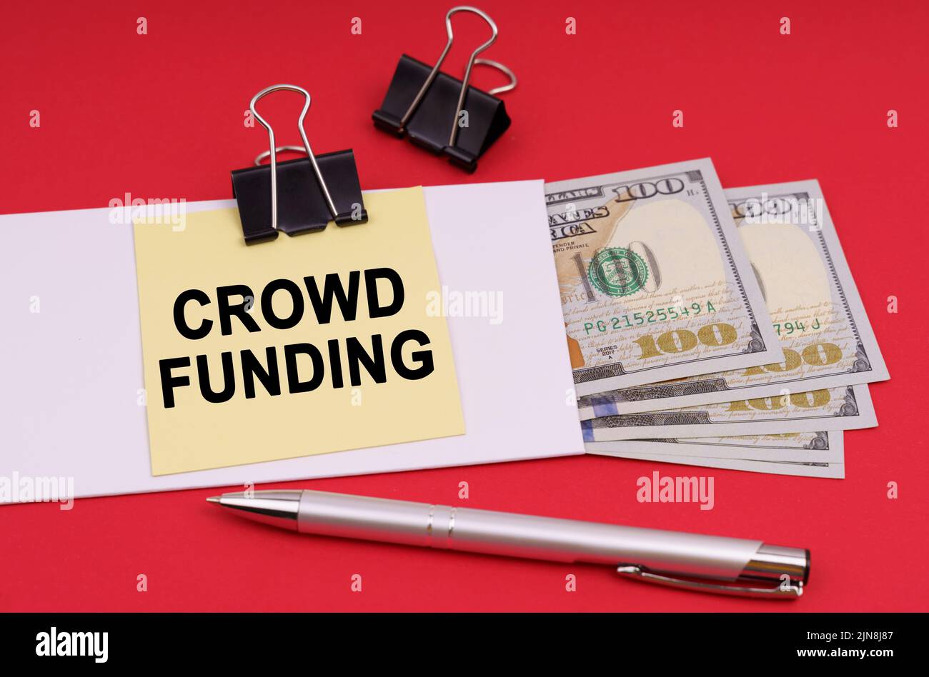 Business concept. On a red background, an envelope with money and a ...