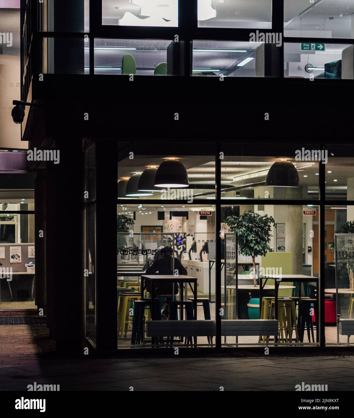 A cozy cafe with a modern interior and people chatting under the ...