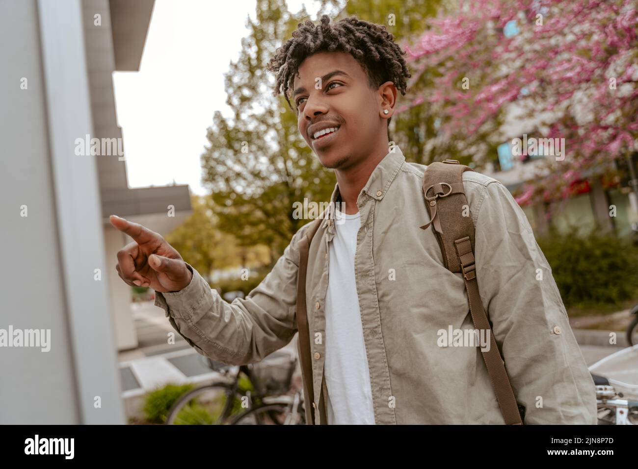 Guy standing looking interested pointing finger Stock Photo - Alamy