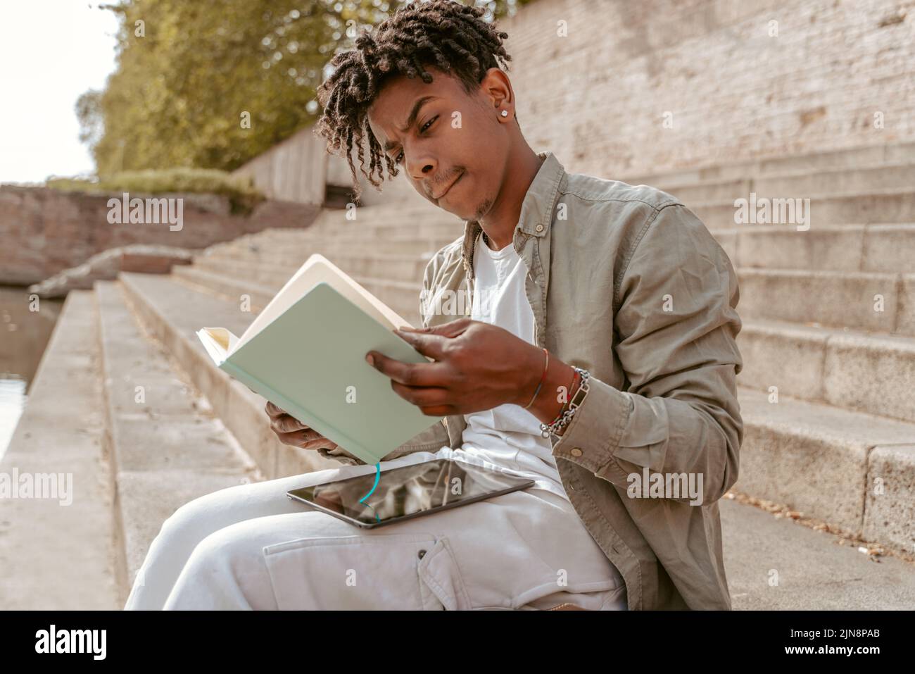 Guy intently looking into notebook reading notes Stock Photo - Alamy