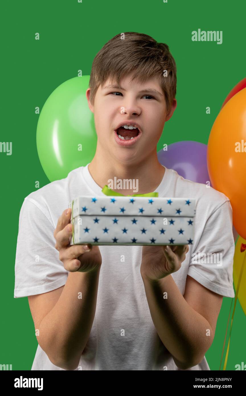 Astonished teenage boy receiving a birthday present Stock Photo - Alamy