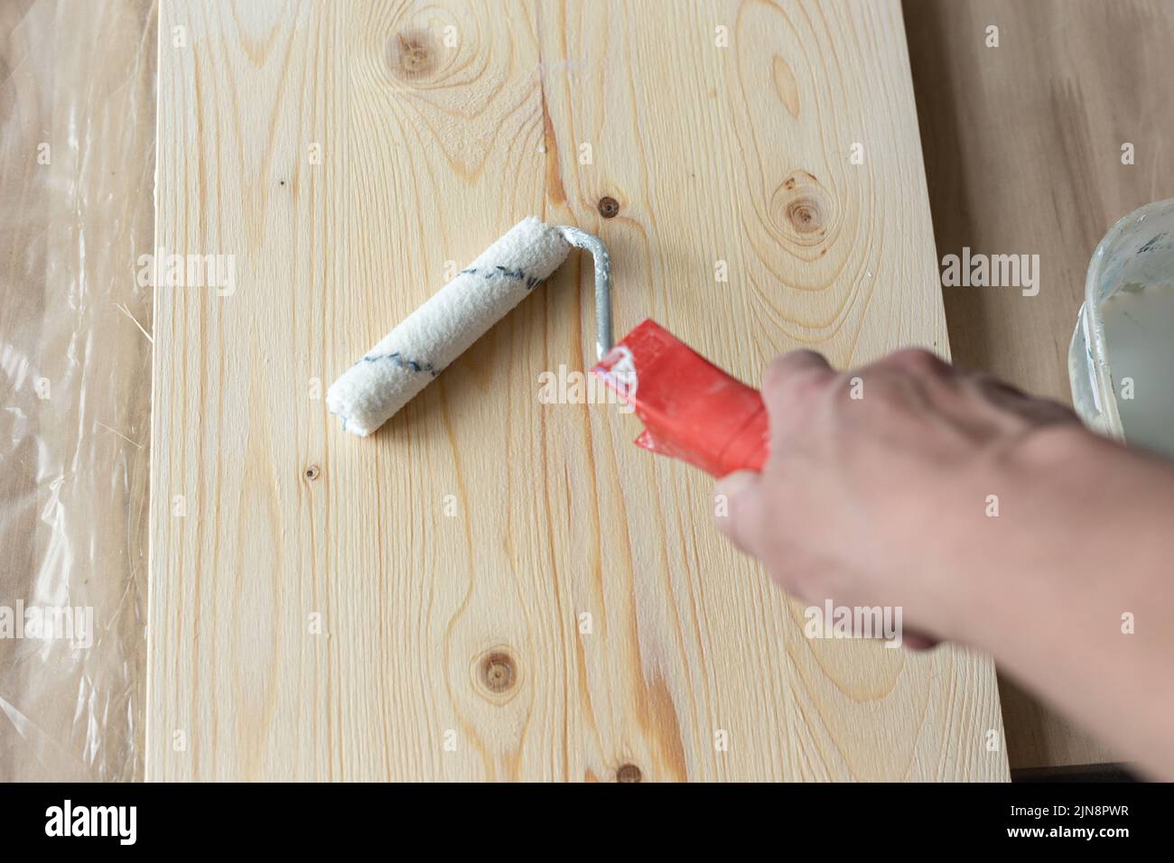 Coating the board with varnish using a roller Stock Photo - Alamy