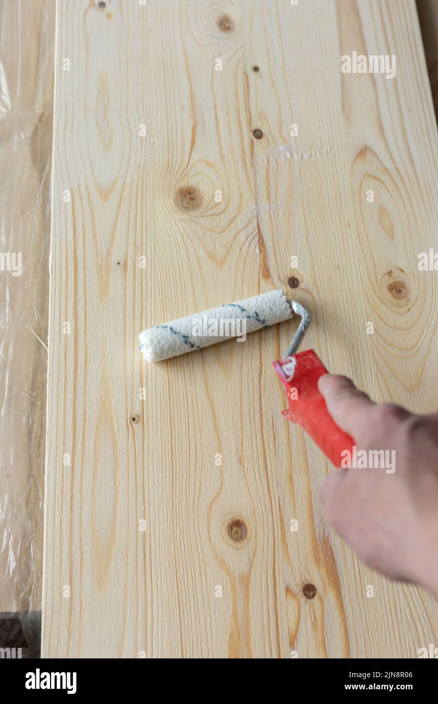 Coating the board with varnish using a roller Stock Photo - Alamy