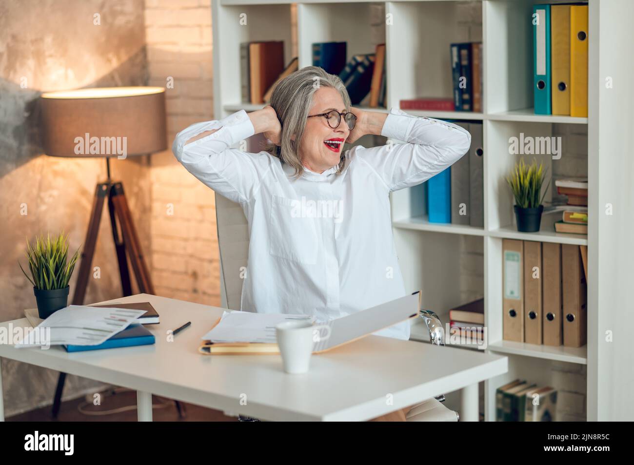 Elegant woman looking tired after long work in the office Stock Photo ...