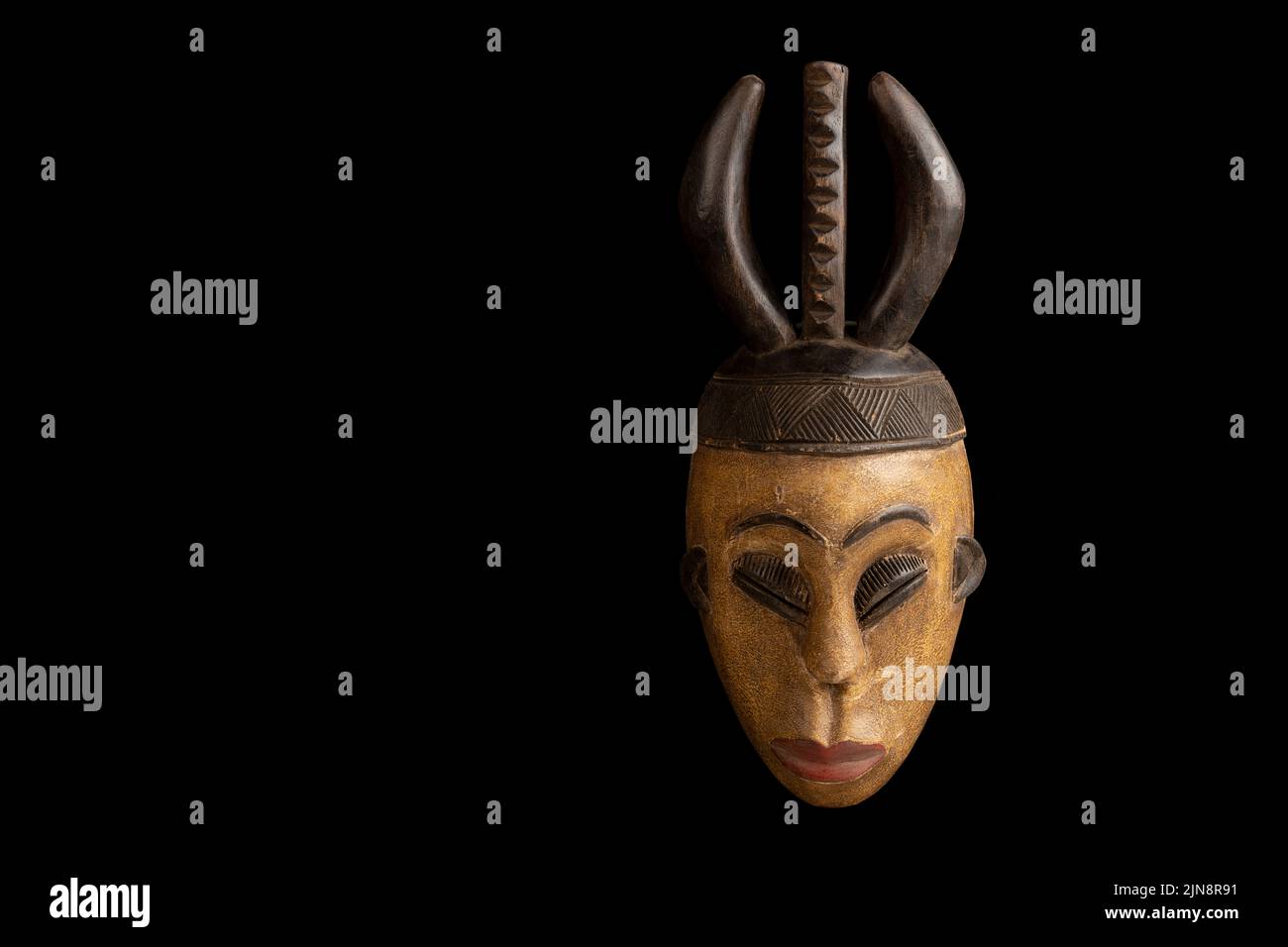 Traditional African wooden mask on a black background Stock Photo - Alamy