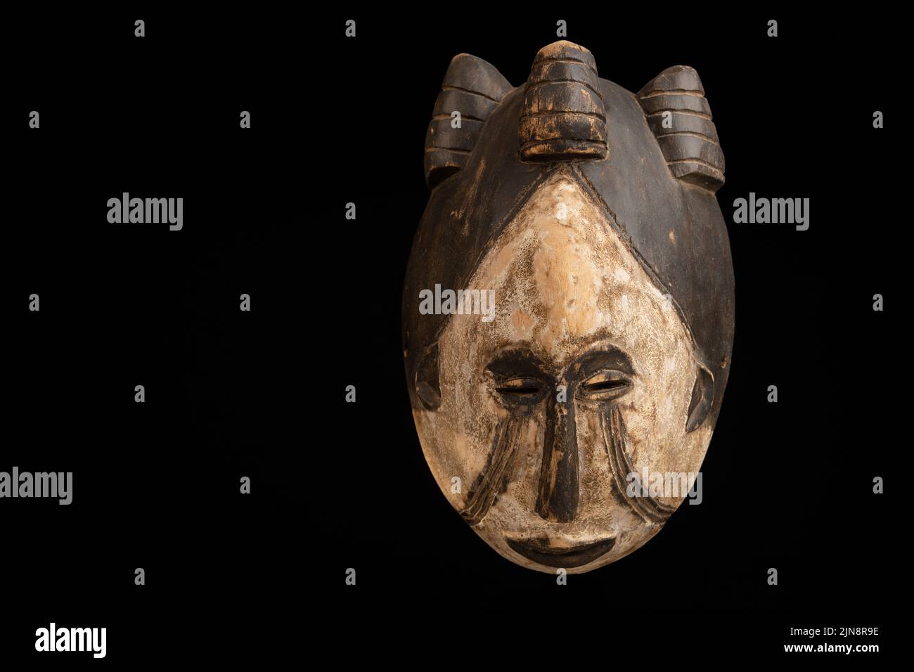 Traditional African wooden mask on a black background Stock Photo - Alamy