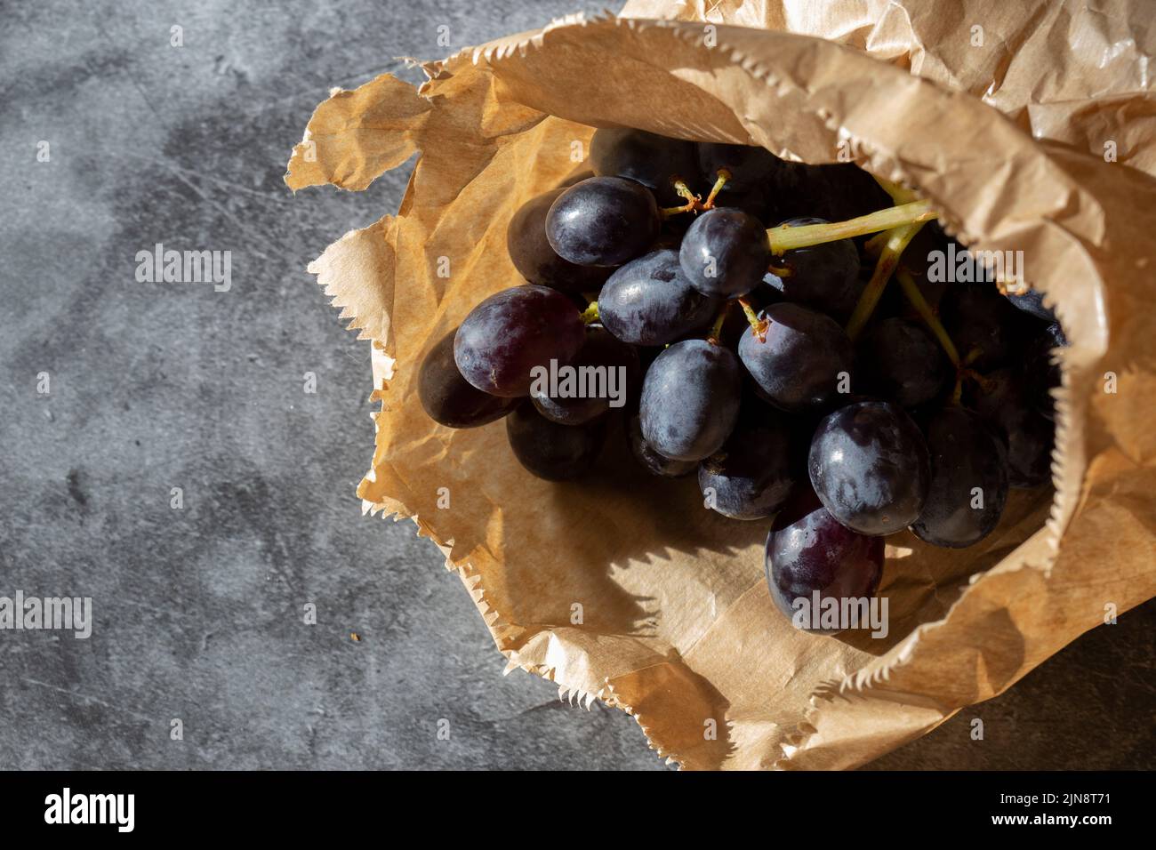 Black grapes in a brown paper bag. Eco friendly recycle packaging to ...