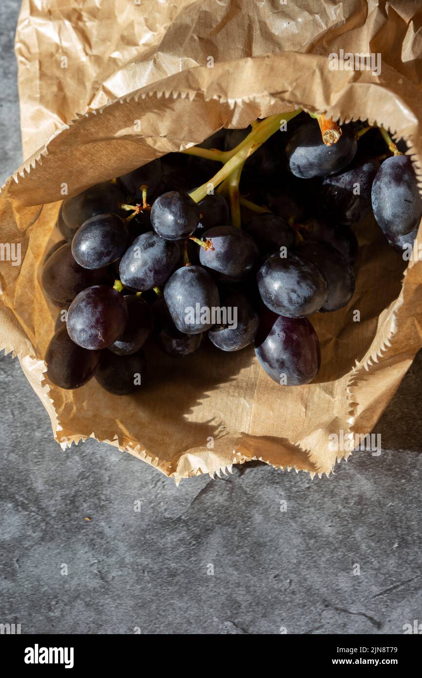 Black grapes in a brown paper bag. Eco friendly recycle packaging to ...