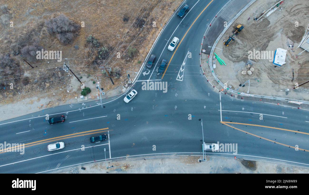 Aerial drone view of cars passing through an intersection near ...