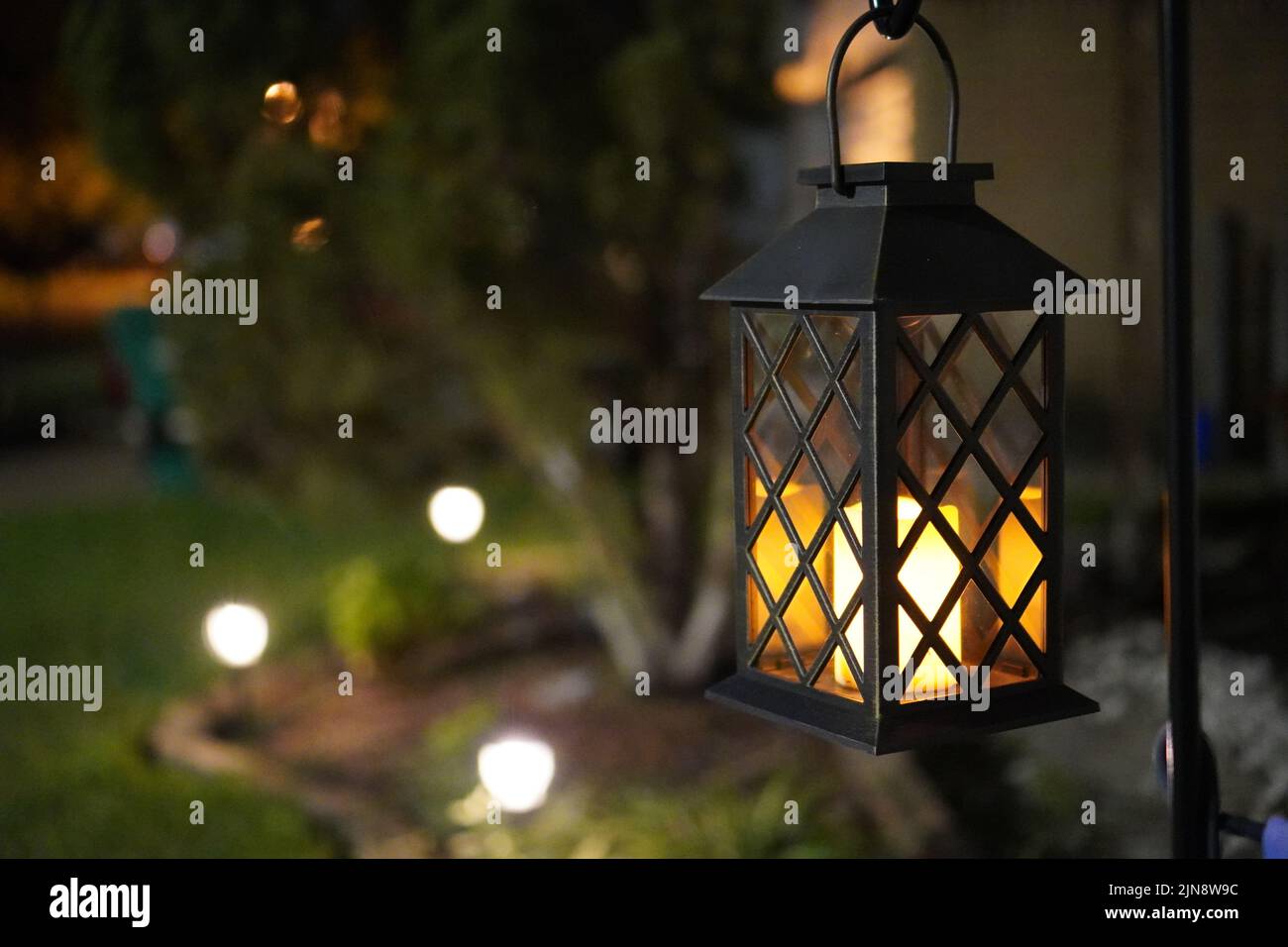 Beautiful night view of the garden illuminated by hanging lamp and ...