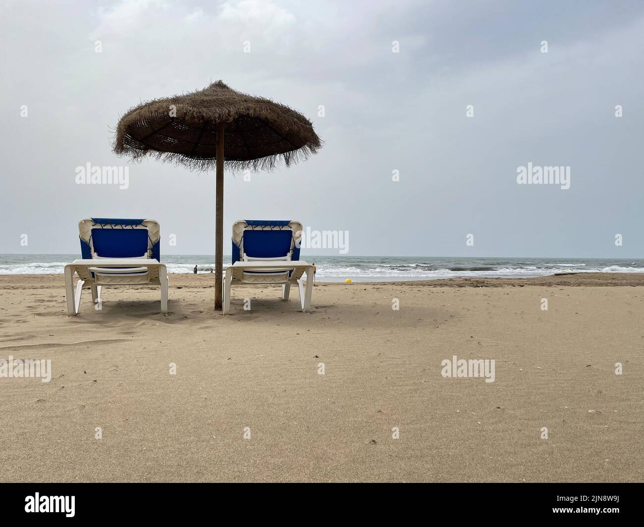 The two sunbeds and parasol at a sandy beach Stock Photo - Alamy