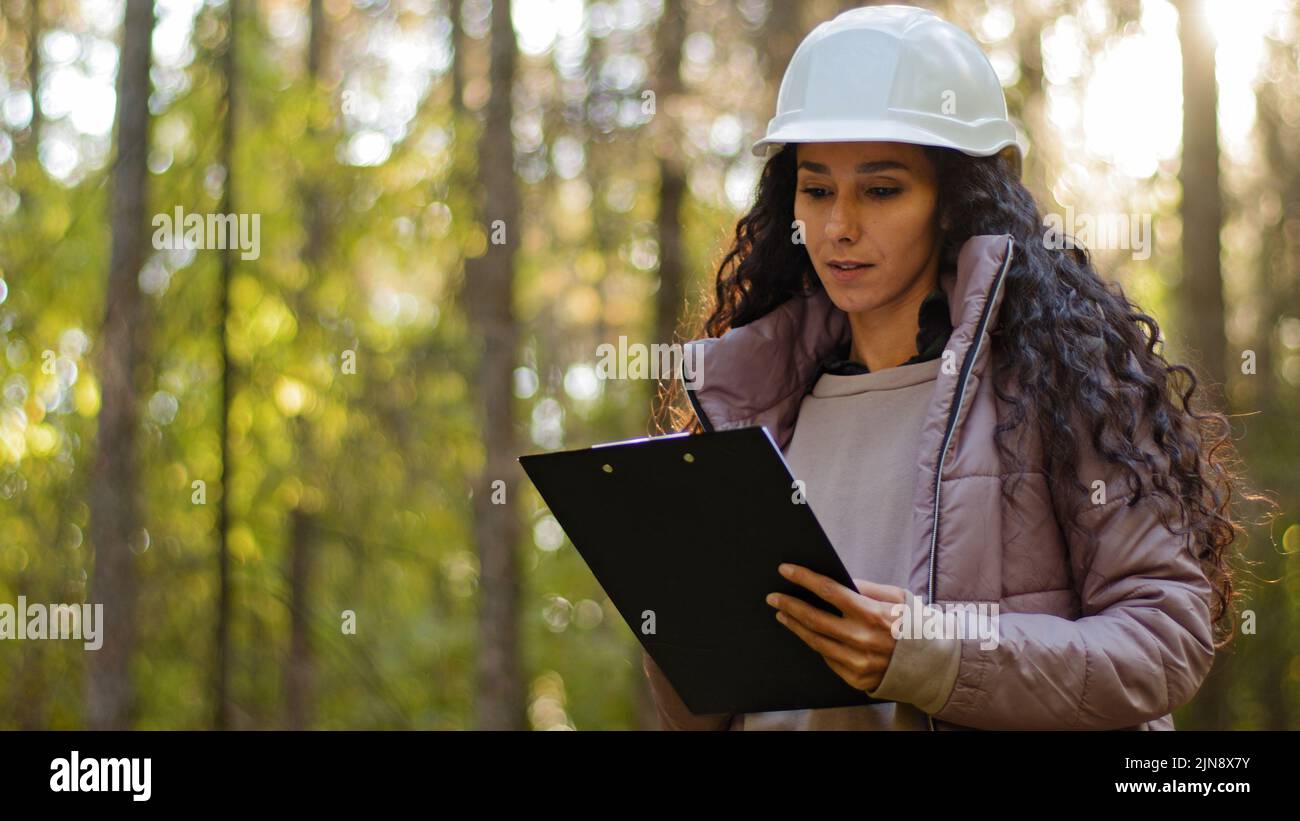 Millennial female technician ecologist looking up at treetops, Young ...