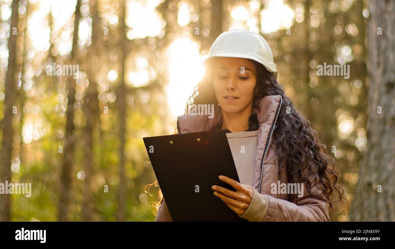 Millennial female technician ecologist looking up at treetops, Young ...