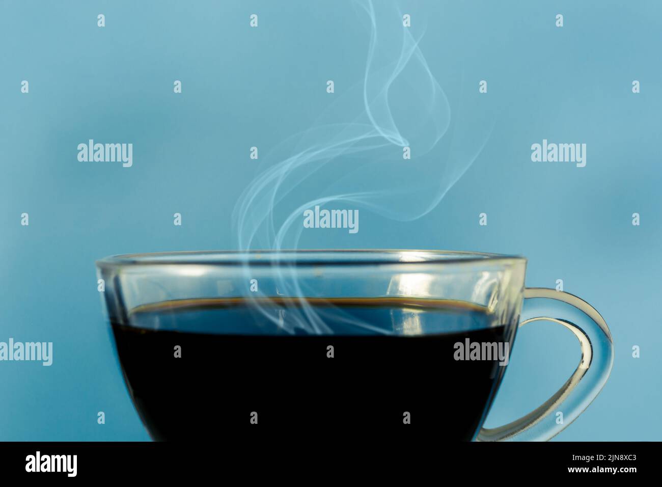 glass cup with black coffee and hot smoke on blue background Stock ...